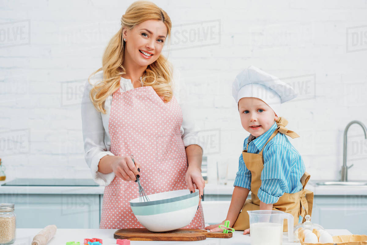 Little boy and mother cooking together in kitchen - Stock Photo - Dissolve