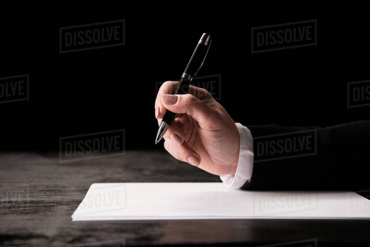 Cropped shot of a female hand holding a pen over a blank paper sheet ...