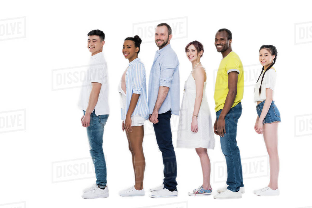 side view of young multiethnic people standing in row and smiling at ...