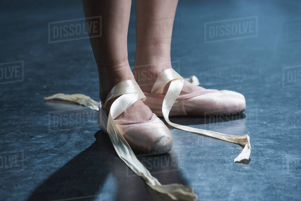 Cropped view of ballet dancer in pointe shoes in dark studio - Royalty ...