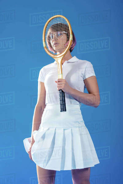 Tennis player covering face with tennis racket isolated on blue ...