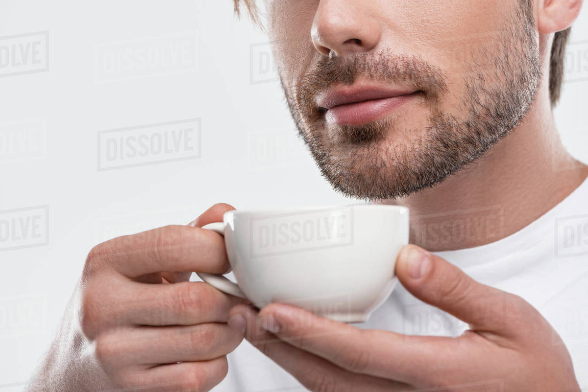 Cropped view of man drinking aromatic coffee, isolated on white ...