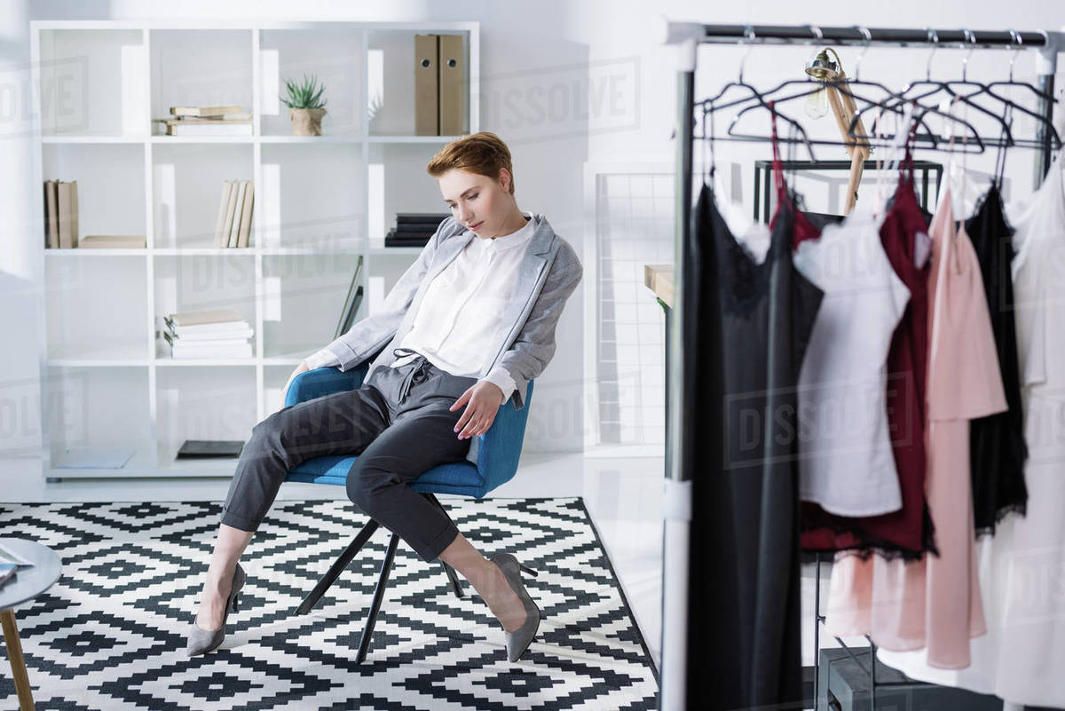 Stylish fashion designer sitting in chair at modern office - Royalty ...