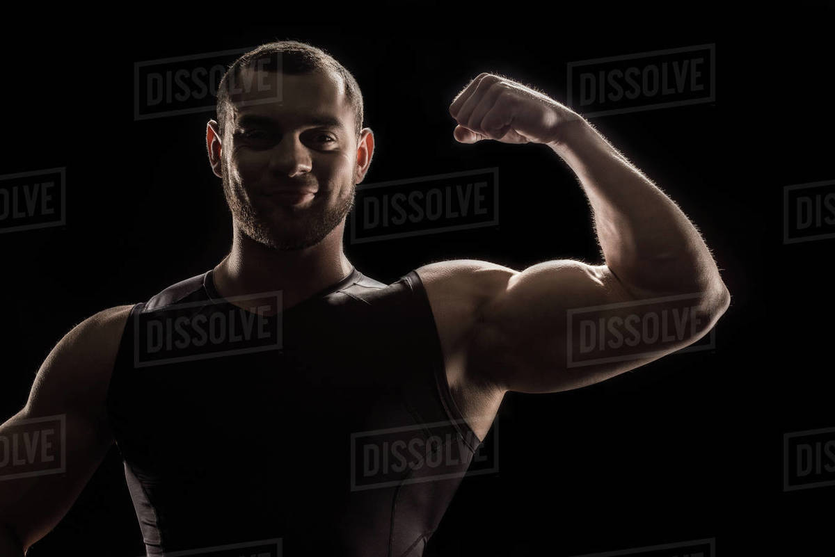 Young Caucasian bodybuilder flexing biceps and looking at camera ...