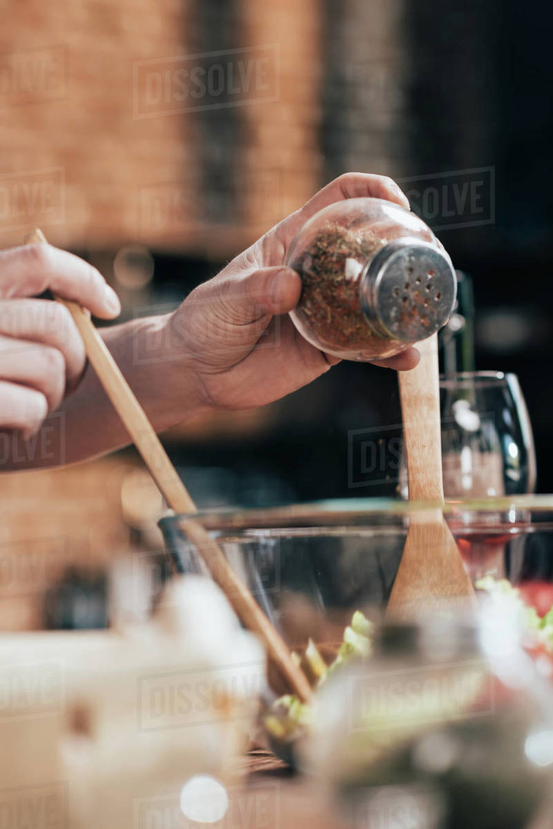 Cropped shot of person adding spices while cooking salad - Royalty-free ...