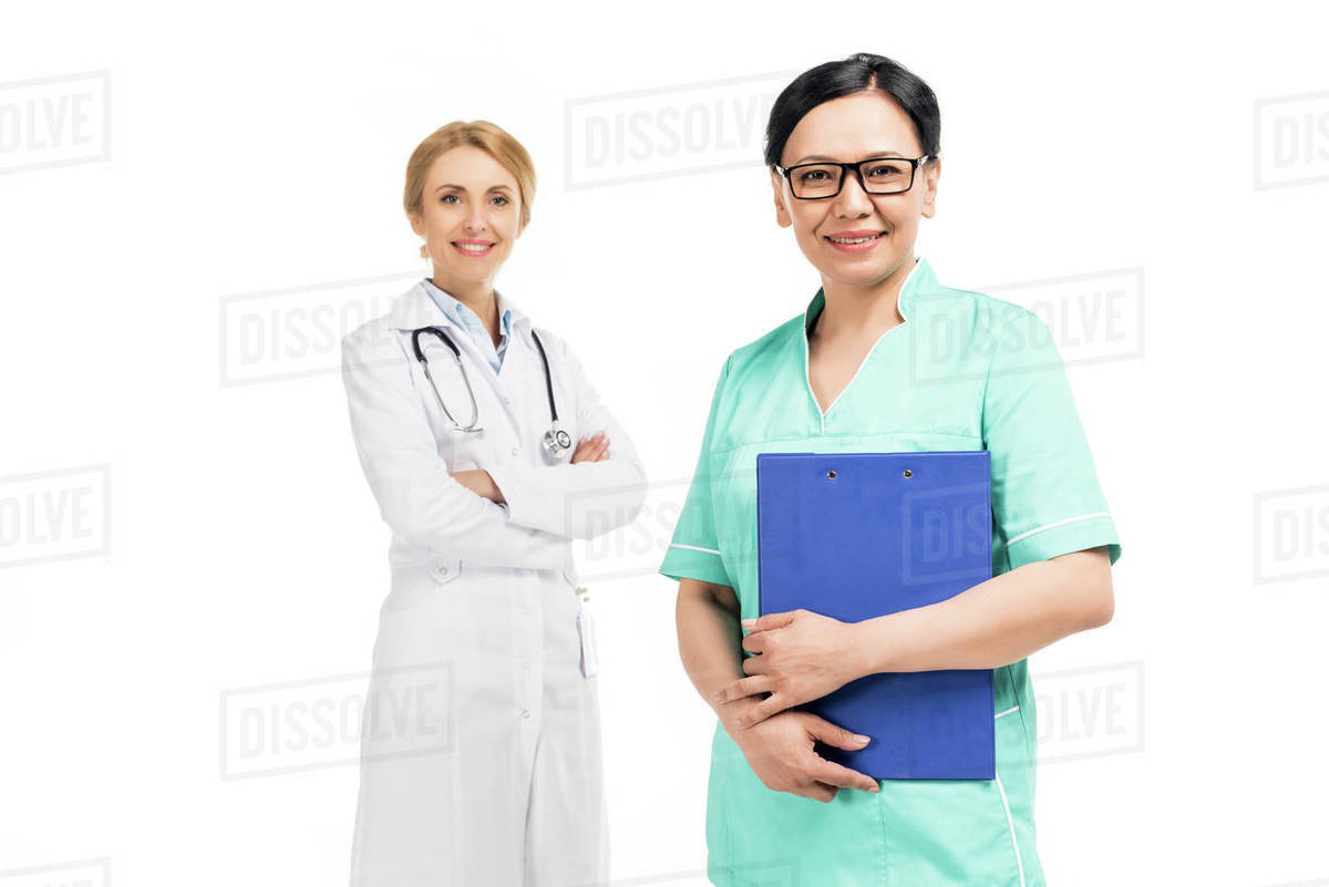 Female medical workers with stethoscope and clipboard smiling at camera ...