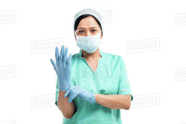 Female Asian surgeon wearing medical gloves and looking at camera ...