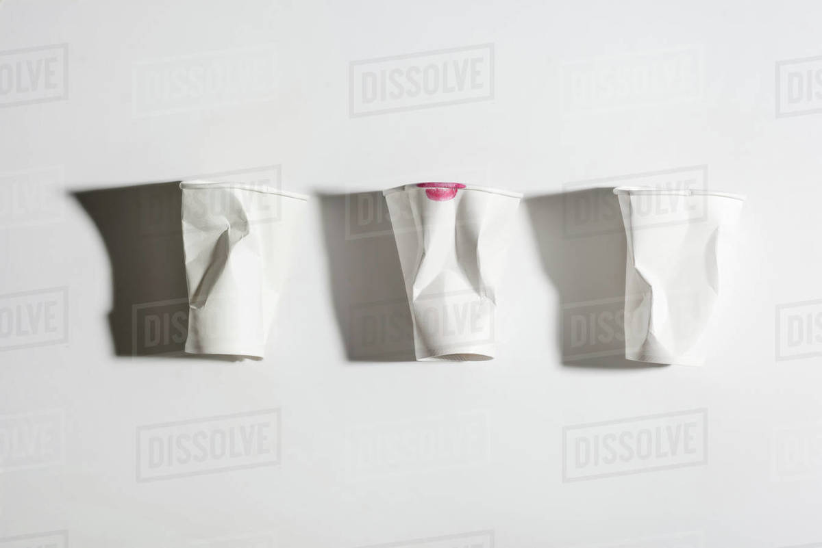 top view of three crumpled used paper cups isolated on white - Royalty ...