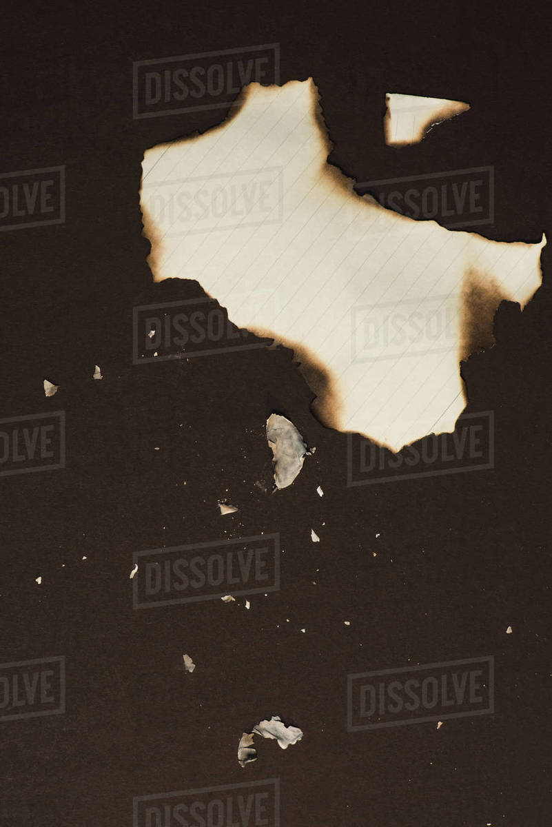 top view of burned pieces of empty writing paper sheet isolated on ...