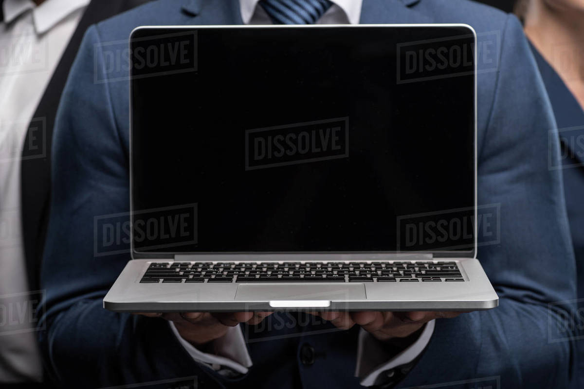 Close-up view of laptop with black screen in hands isolated on black ...