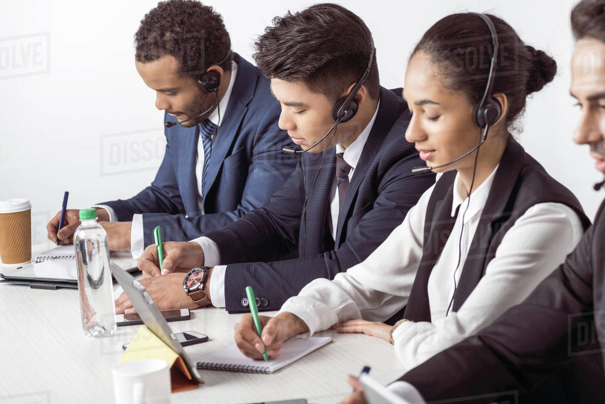 Group of professional call center operators using digital devices and ...