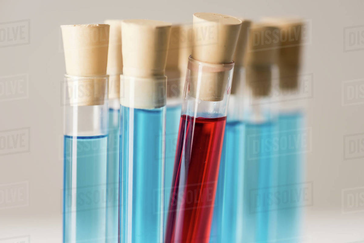 Close-up shot with row of long test tubes with red and blue liquid ...