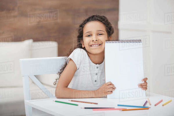 Smiling African American girl showing empty drawing album - Royalty ...