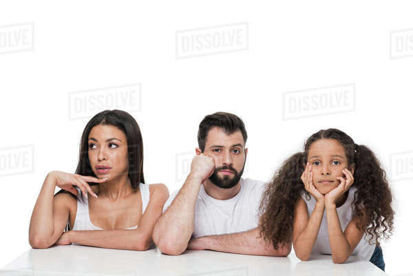 Pensive multiethnic family sitting together with hands on faces ...