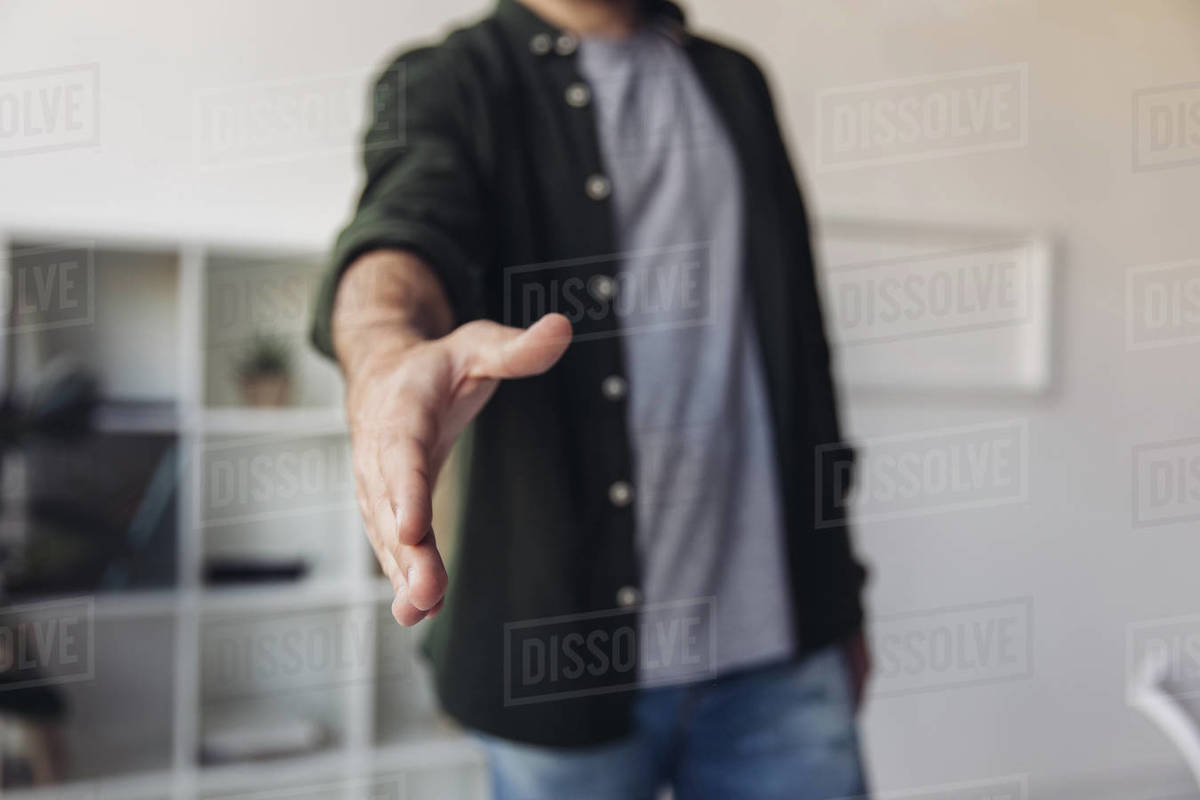 Cropped shot of man reaching hand for handshake while standing in ...