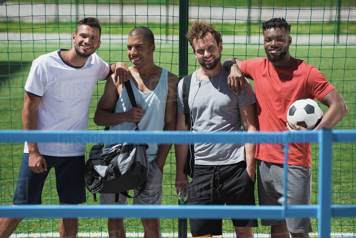 Multicultural soccer team resting on stadium together before game ...