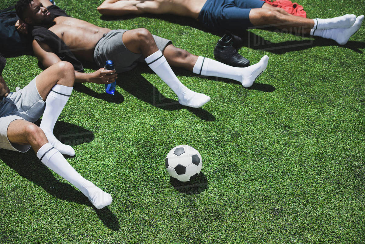 Soccer players resting on football field after soccer match - Royalty ...