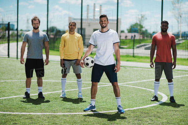 Multiethnic soccer team standing on soccer pitch after game - Royalty ...