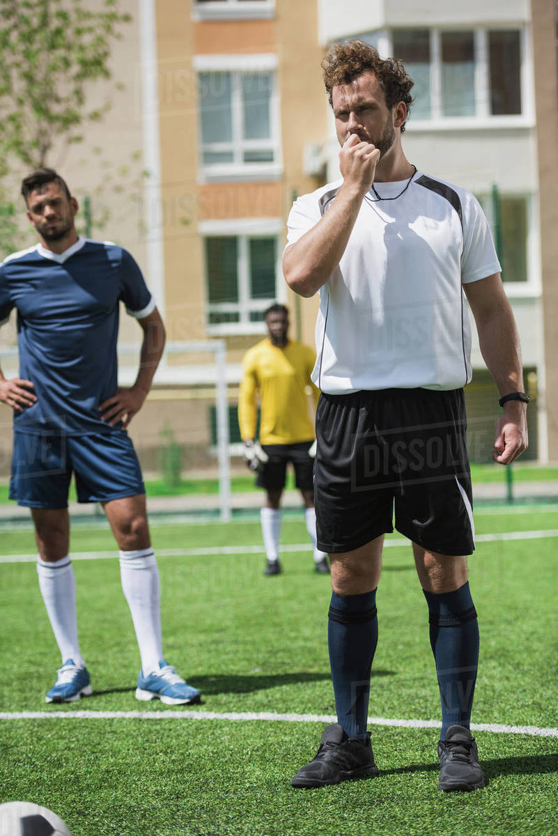 Soccer referee whistling in whistle on soccer pitch during game ...