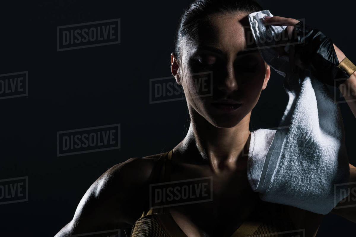 Sweaty tired bodybuilder with towel after training, isolated on black ...