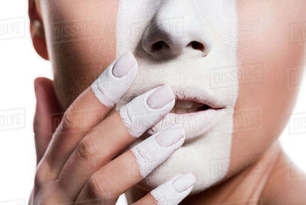 Cropped image of woman with white paint on face and fingers touching ...