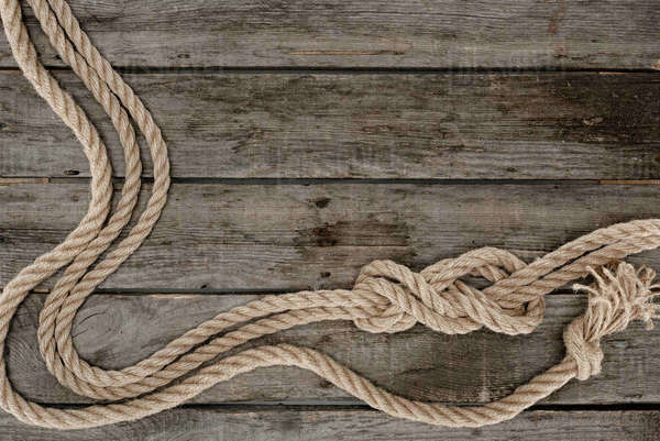 Flat lay with marine ropes with knots on grunge wooden tabletop ...