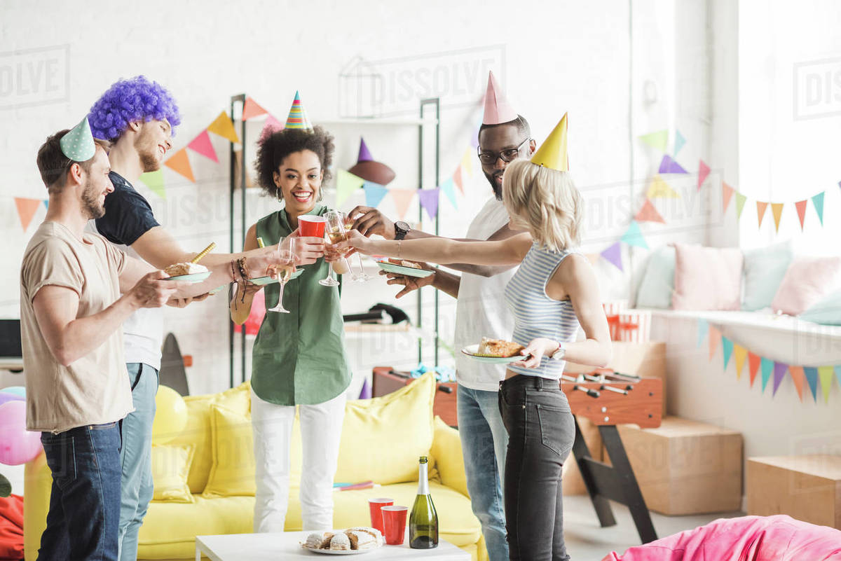 Cheerful diverse people toasting with champagne at birthday party ...