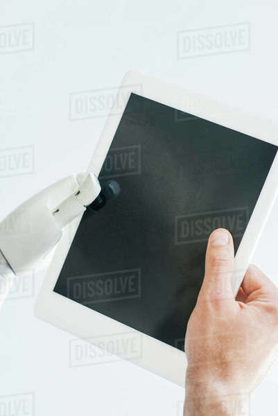 close-up view of human hand and robotic arm holding digital tablet with ...