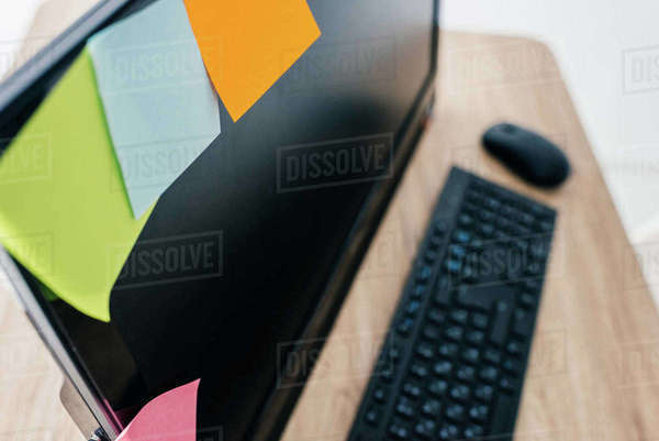 High angle view of colorful post its on blank computer monitor at table ...