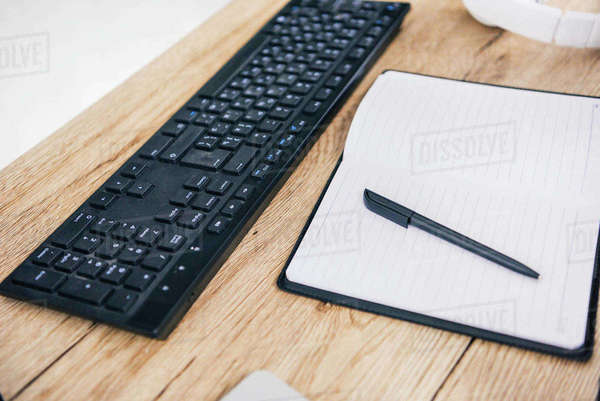 Close-up shot of computer keyboard, empty textbook with pen and ...
