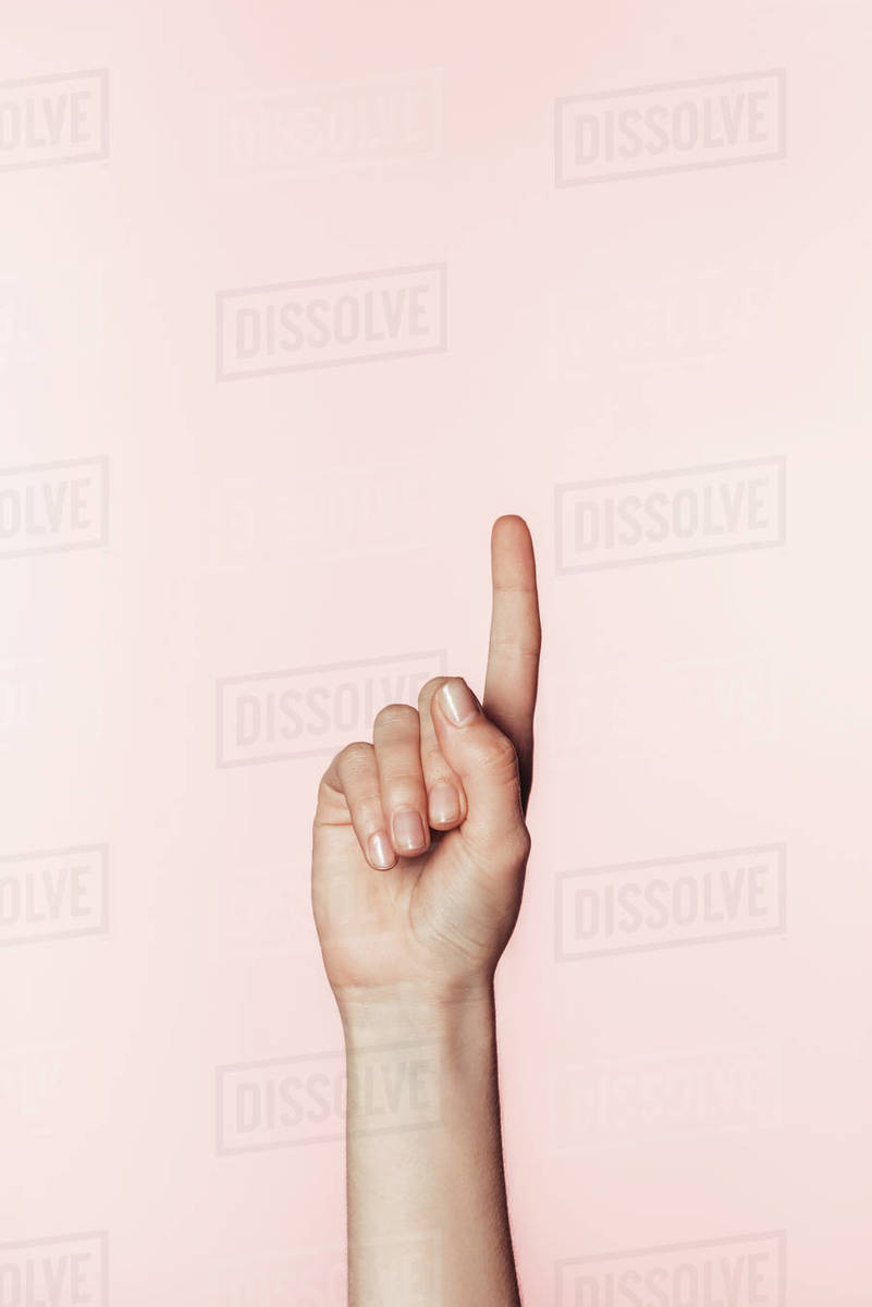 cropped image of woman doing finger raised gesture isolated on pink ...