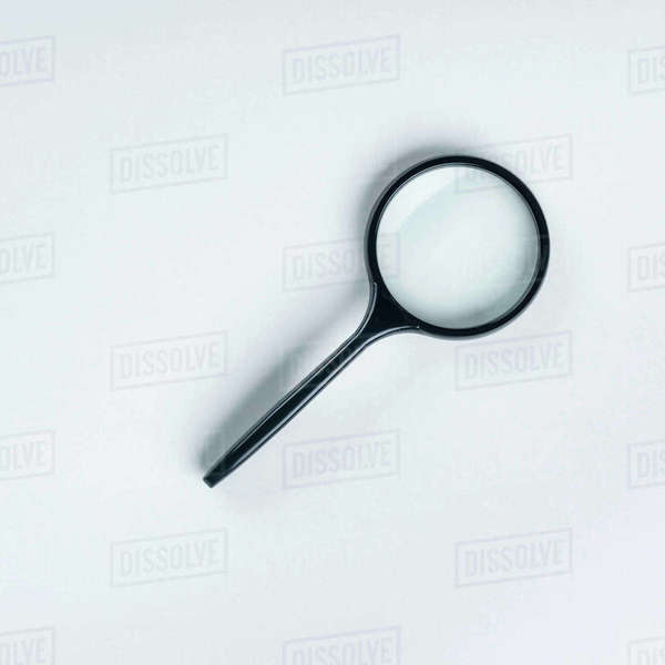 closeup shot of magnifier on gray background - Stock Photo - Dissolve