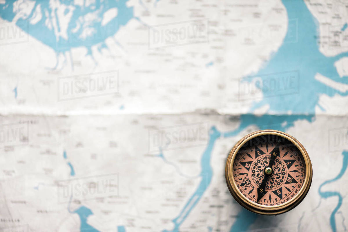 top view of vintage compass on map - Royalty-free Stock Photo | Dissolve