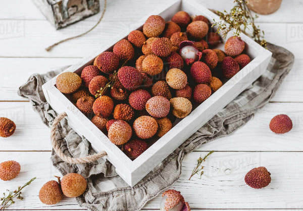 closeup shot of lychees in wooden box on white table - Royalty-free ...