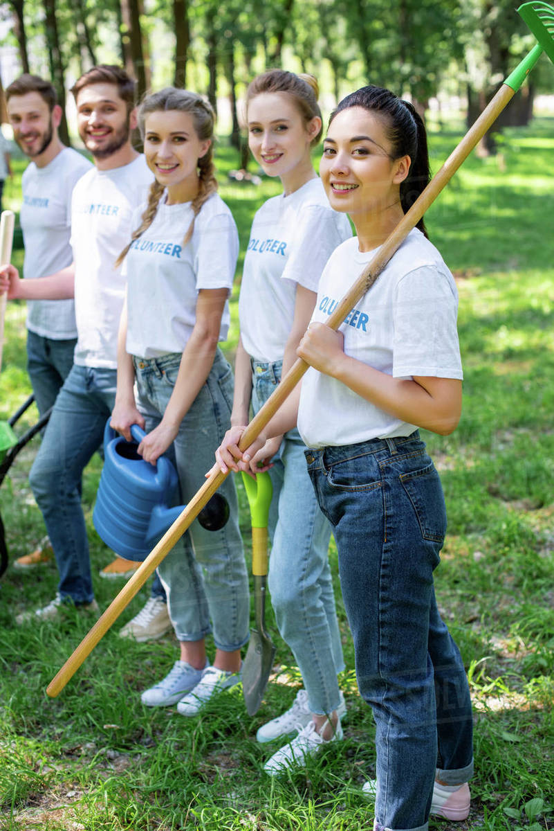 Young smiling volunteers standing in park - Royalty-free Stock Photo ...