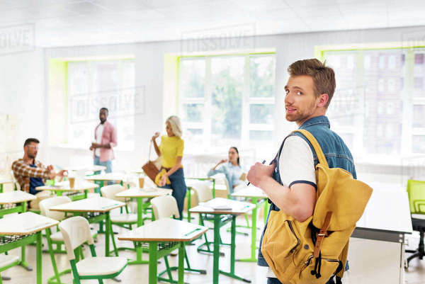 Stylish young student in classroom of college with blurred classmates ...