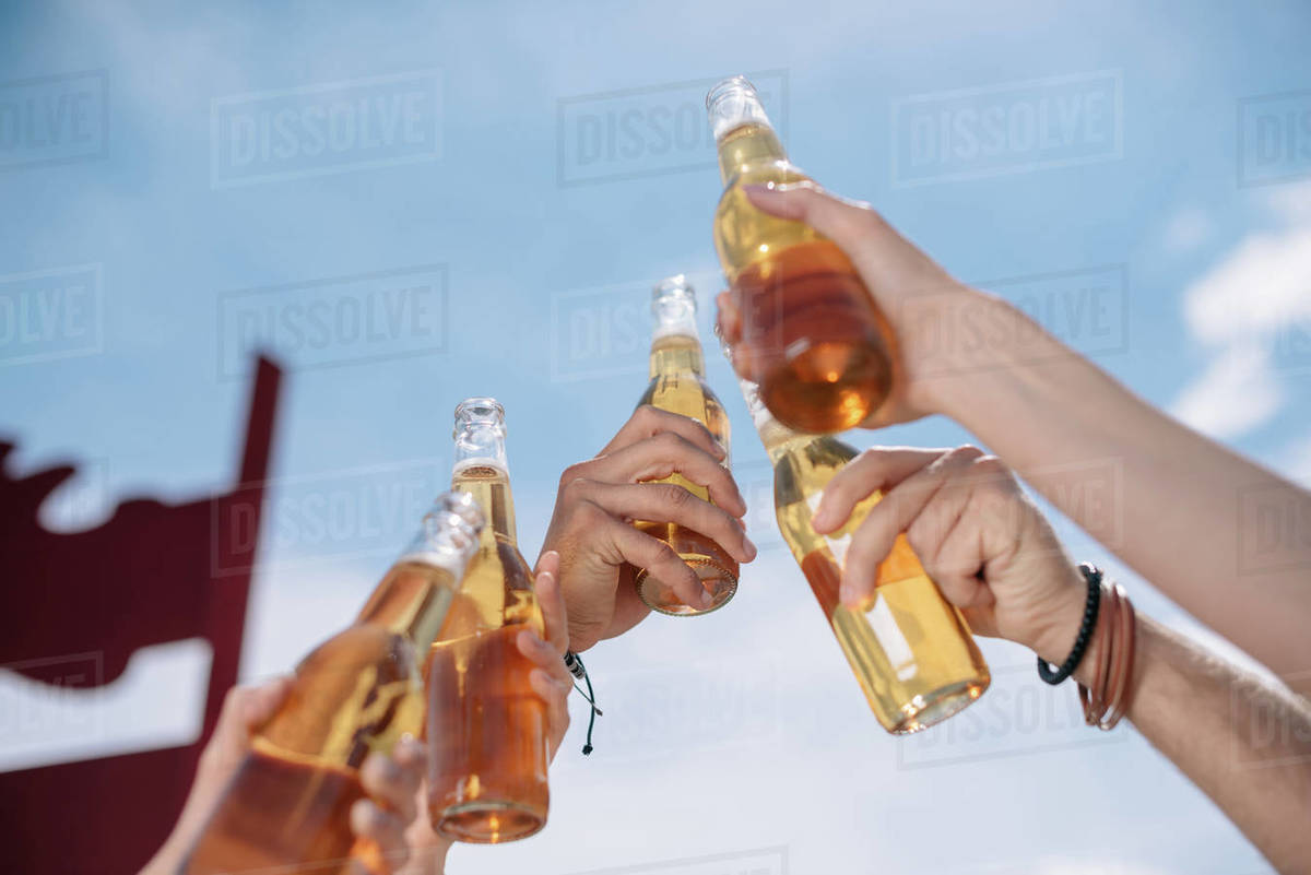 Cropped shot of young people clinking beer bottles outdoors - Stock ...