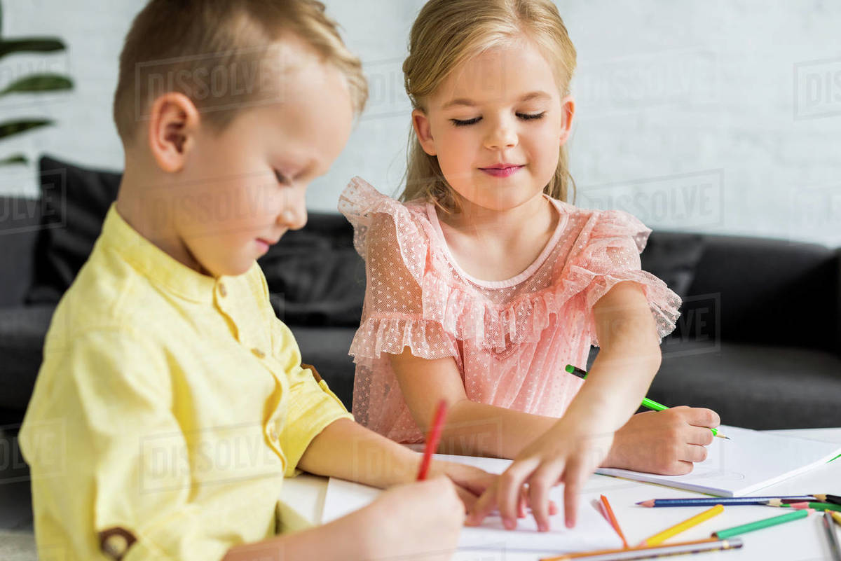 Adorable siblings drawing with colored pencils at home - Royalty-free ...