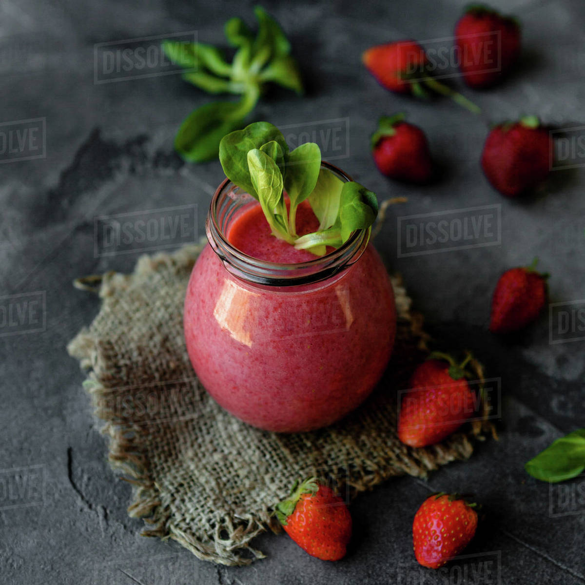 Organic strawberry fruit smoothie with green leaves on wooden ...