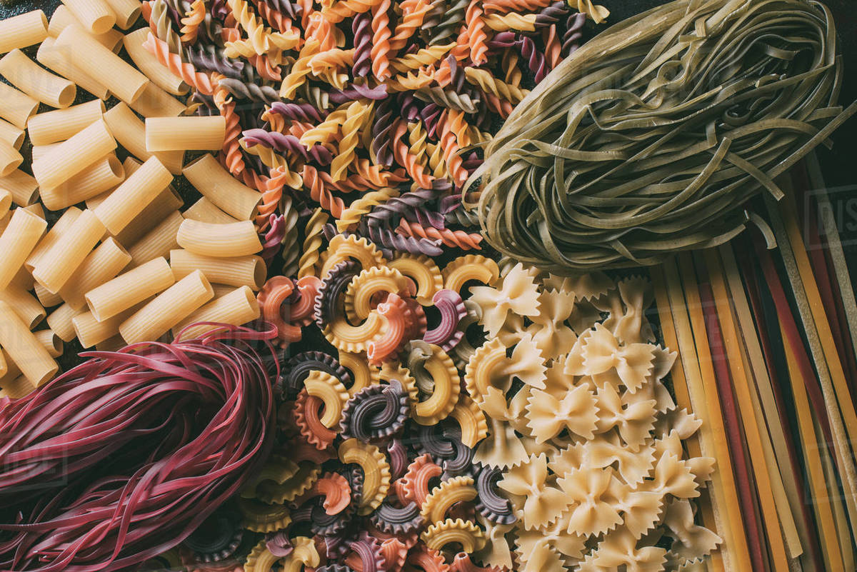 elevated view of different types of colorful pasta - Stock Photo - Dissolve