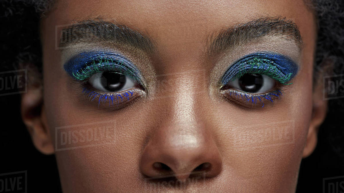 cropped shot of african american woman with blue eye shadows looking at ...