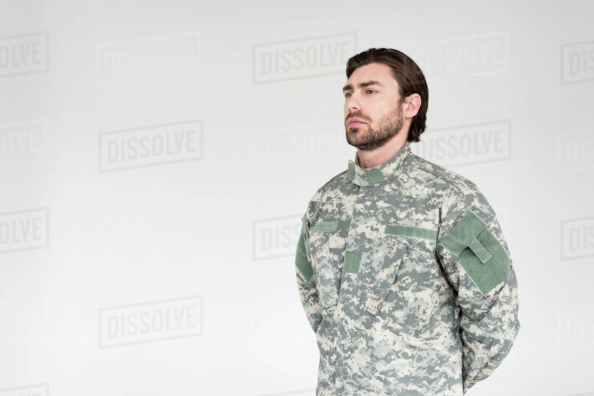 side view of confident bearded soldier in military uniform looking away ...
