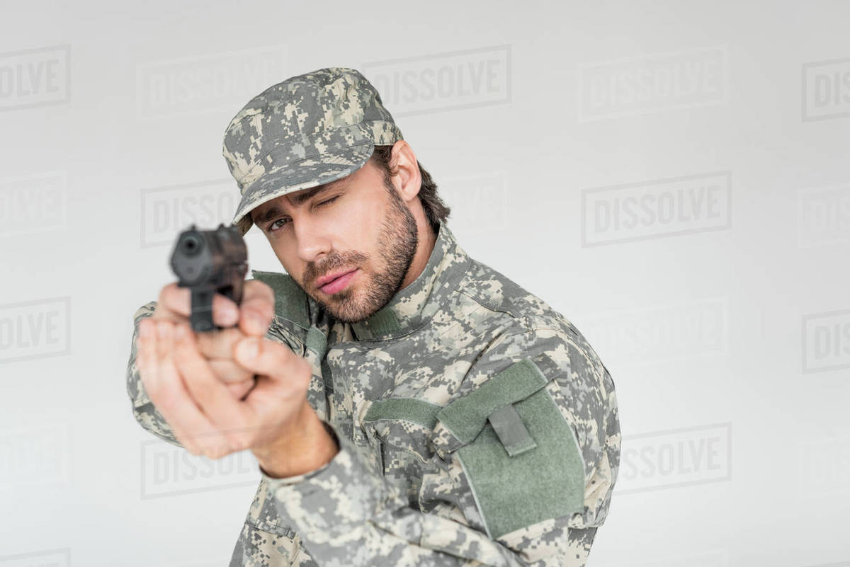 selective focus of male soldier in military uniform holding gun ...
