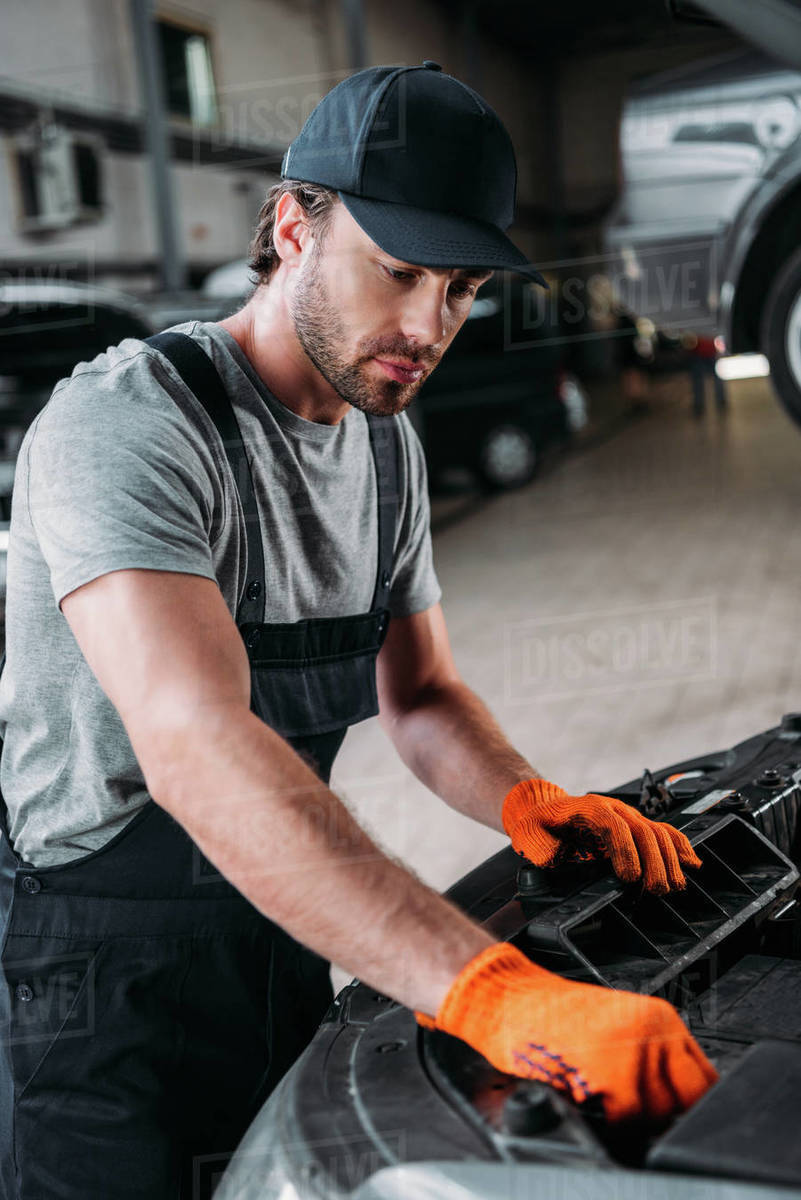 Professional manual worker repairing car in mechanic shop - Royalty ...
