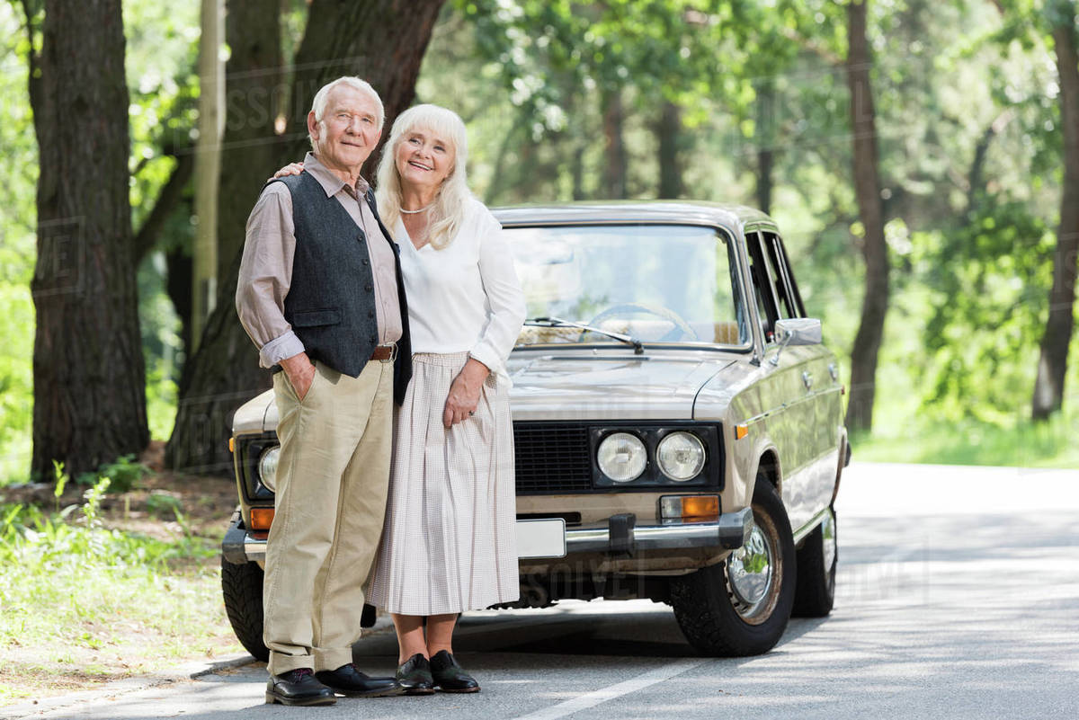 senior family standing near beige retro car - Royalty-free Stock Photo ...