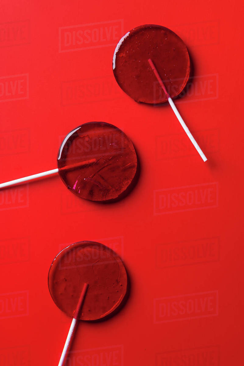 top view of three lollipops on red surface - Royalty-free Stock Photo ...