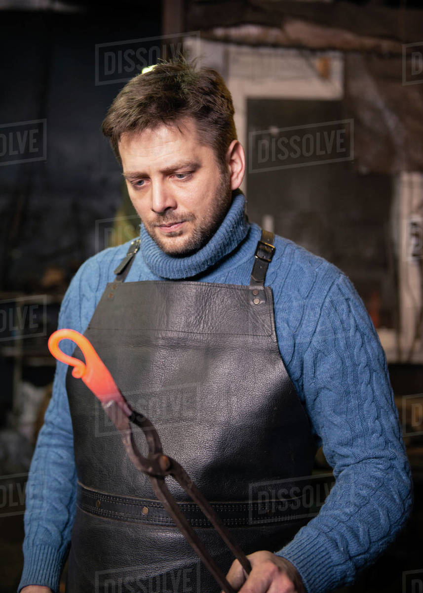 Male blacksmith using blacksmith tongs for red hot metal - Stock Photo ...