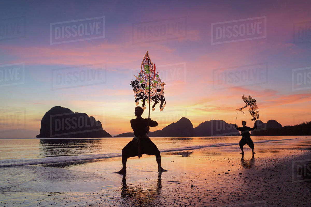 Rear view of two men performing Traditional Thai Shadow Puppet Show on ...