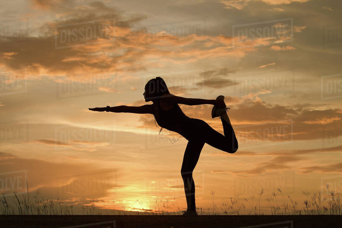 Silhouette of a woman doing dancer pose at sunset, Thailand - Royalty ...