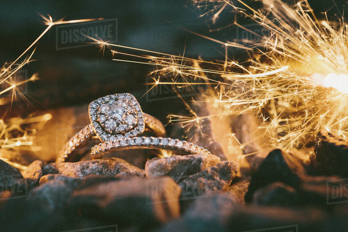 Wedding Rings hang on a sparkler as it burns down illuminating the ...